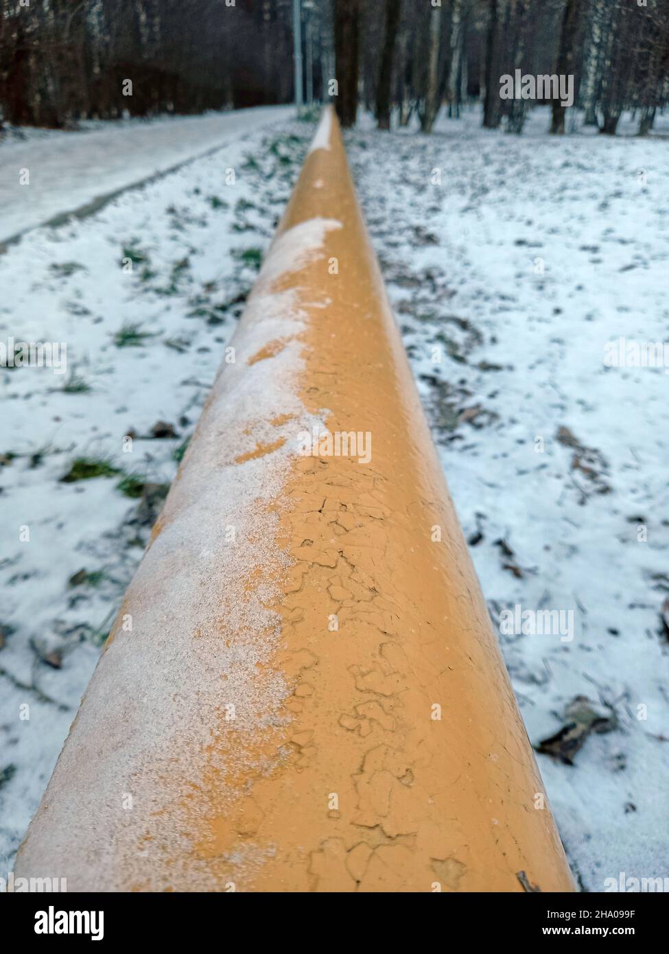 Yellow gas pipe in the open air in winter. Gas pipeline on the street ...
