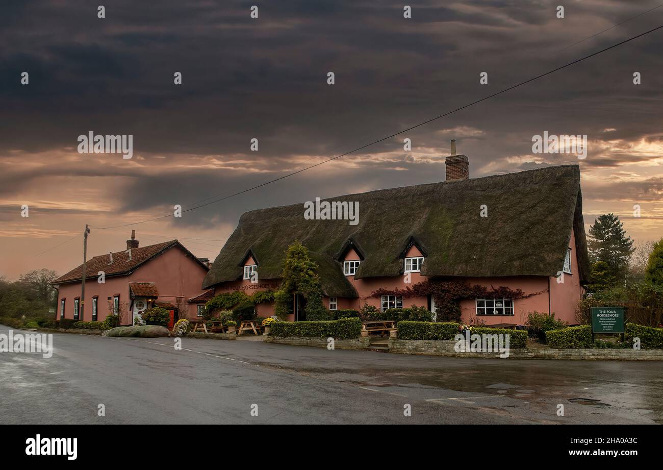 Dark clouds over the Four Horseshoes pub in Thornham Magna, Suffolk, UK ...