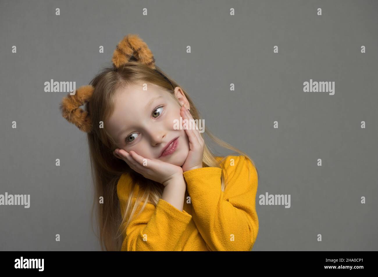 Cute blond girl with tiger ears. A headdress with tiger ears. New Year ...