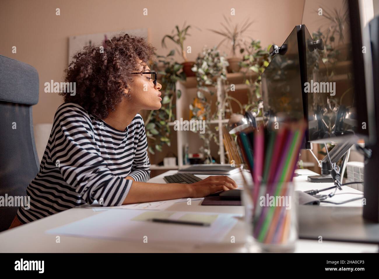 Multiethnic woman is using computer at home Stock Photo - Alamy