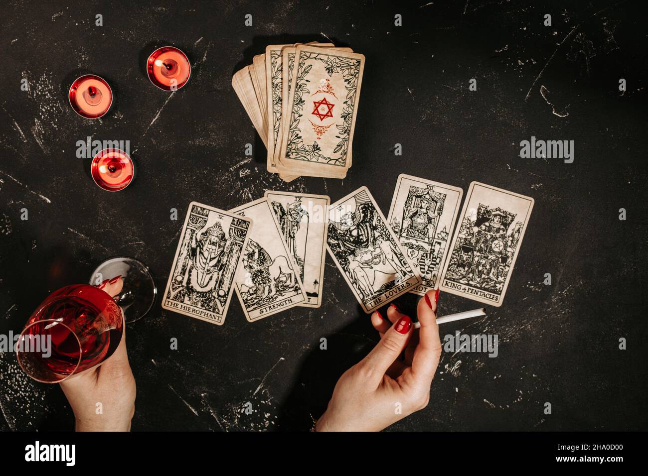 Tarot cards and female hands of fortune teller on black magic table ...