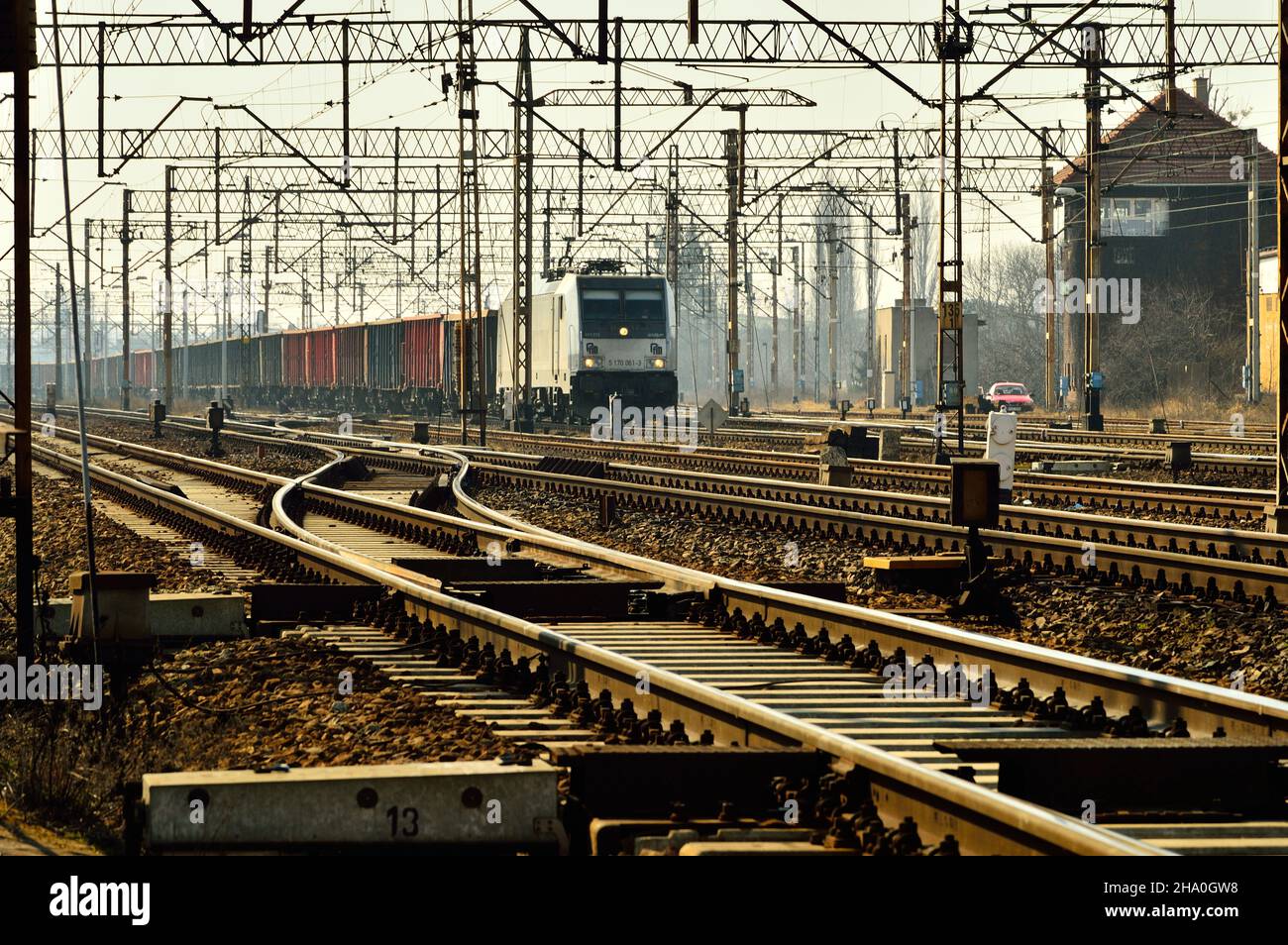 Electric locomotive and freight wagons on railroad tracks on a sunny ...