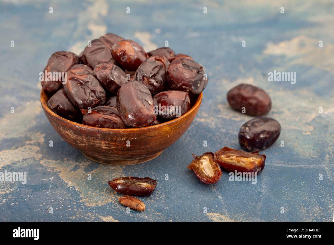 Dried dates in wooden bowl on blue background. Dates are excellent ...