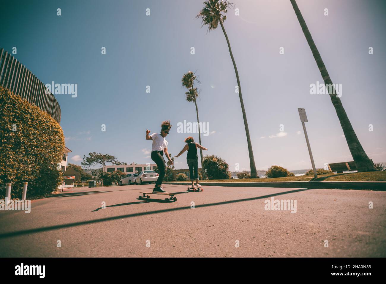 Female skateboarders skating on a boardwalk Stock Photo - Alamy