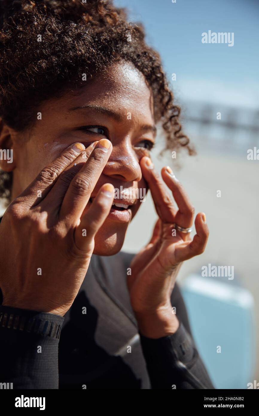 Woman applying sunscreen on the beach Stock Photo - Alamy