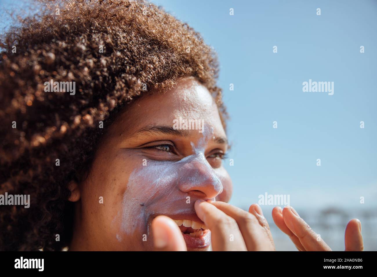 Woman applying sunscreen on the beach Stock Photo - Alamy