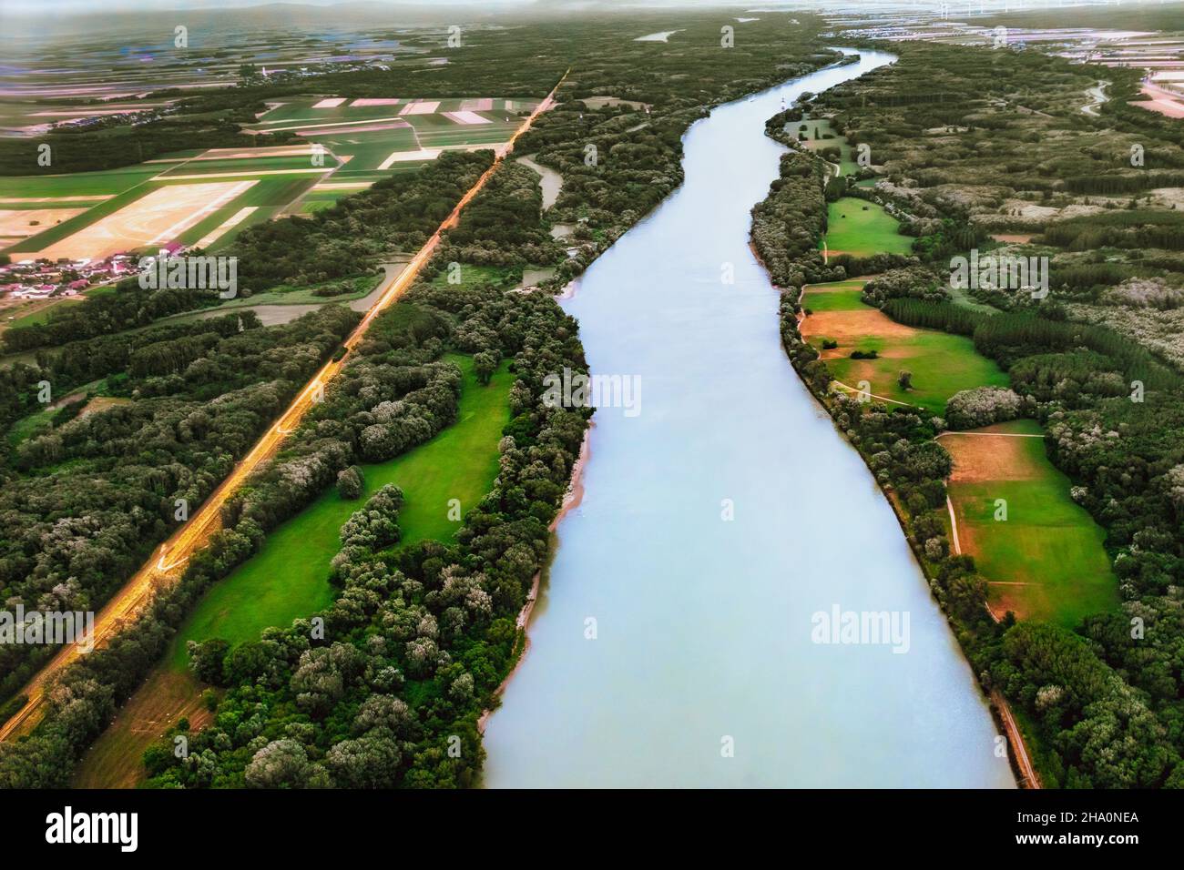 Beautiful view of river water flowing along the fields with thickly ...