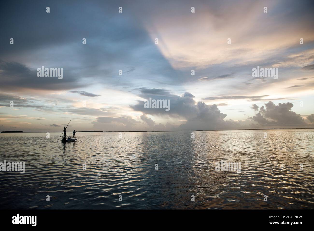 A woman fly fishing from a boat in the florida keys at sunset Stock ...