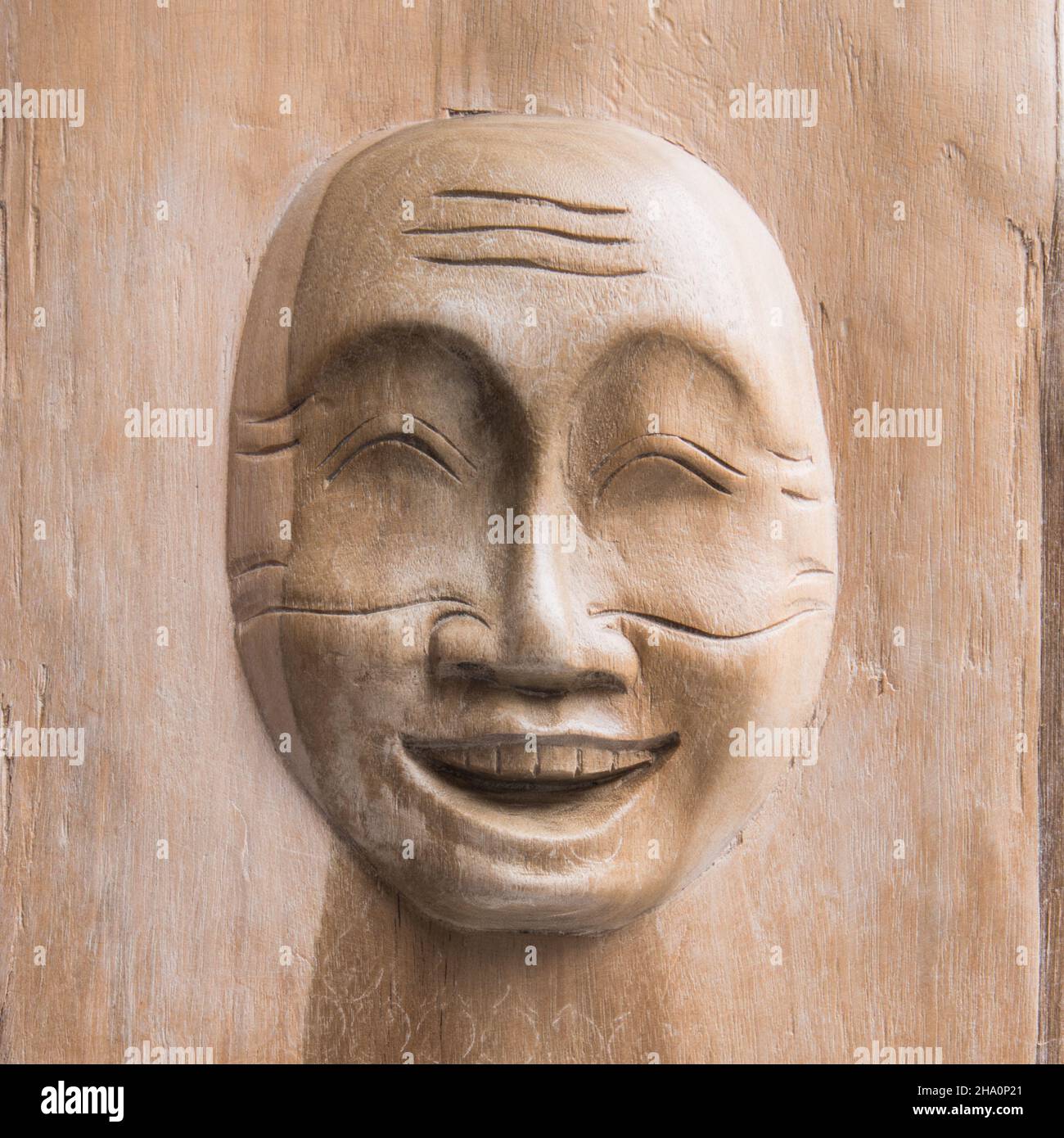 A cheery carved face in a vertical-grain piece of timber Stock Photo ...