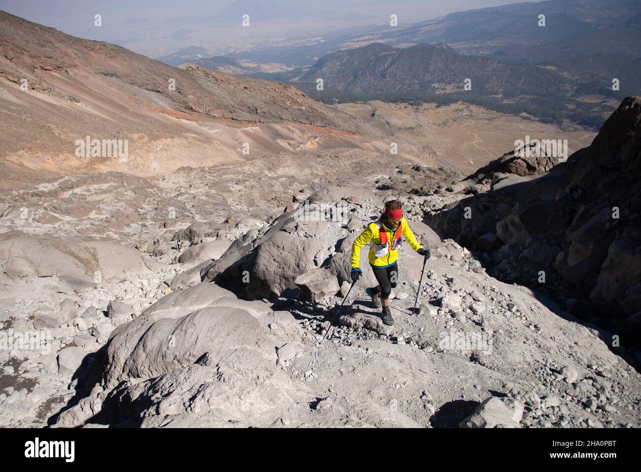 One man with poles hiking through rough terrain at Pico de Orizaba ...