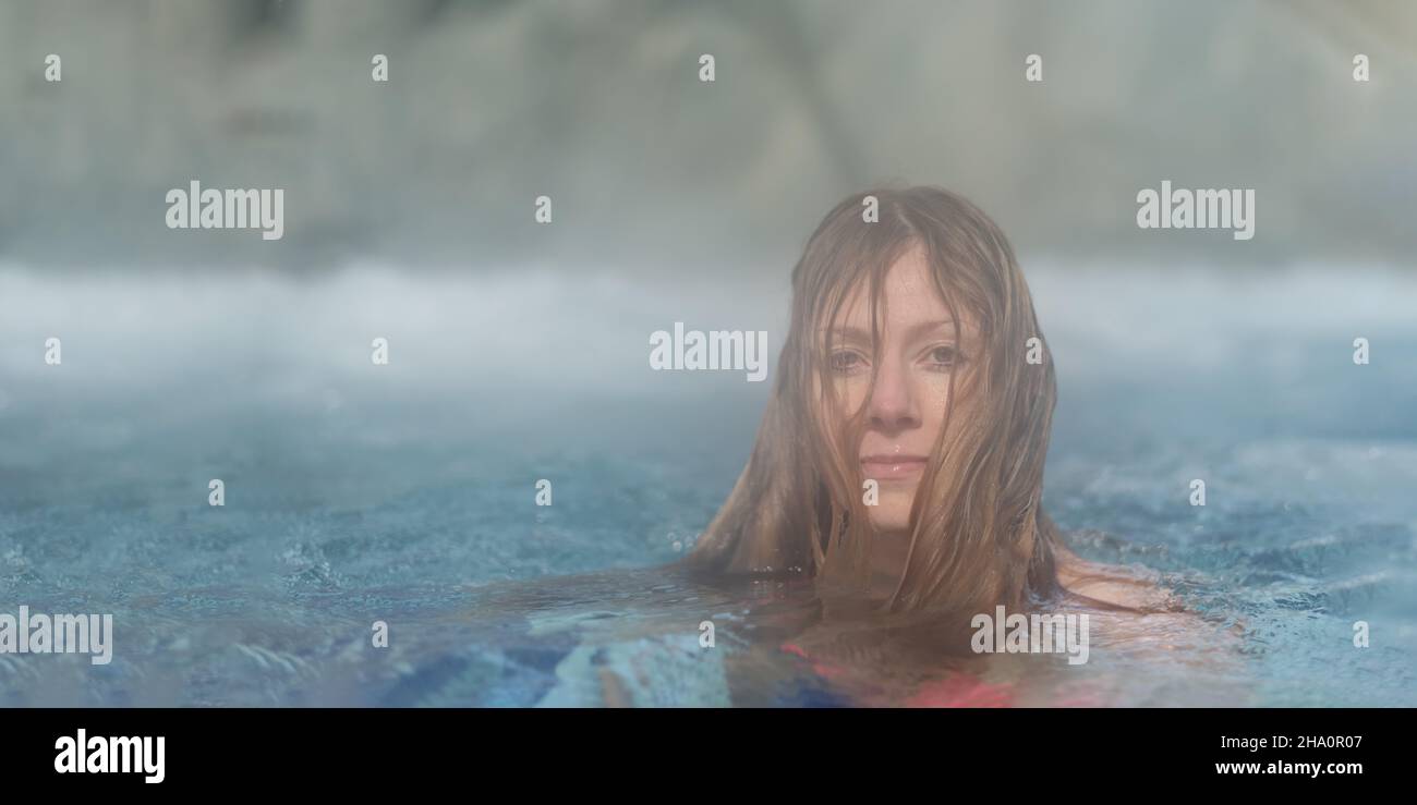 Pretty blond woman portrait in pink bikini relaxes in thermal bath hot ...