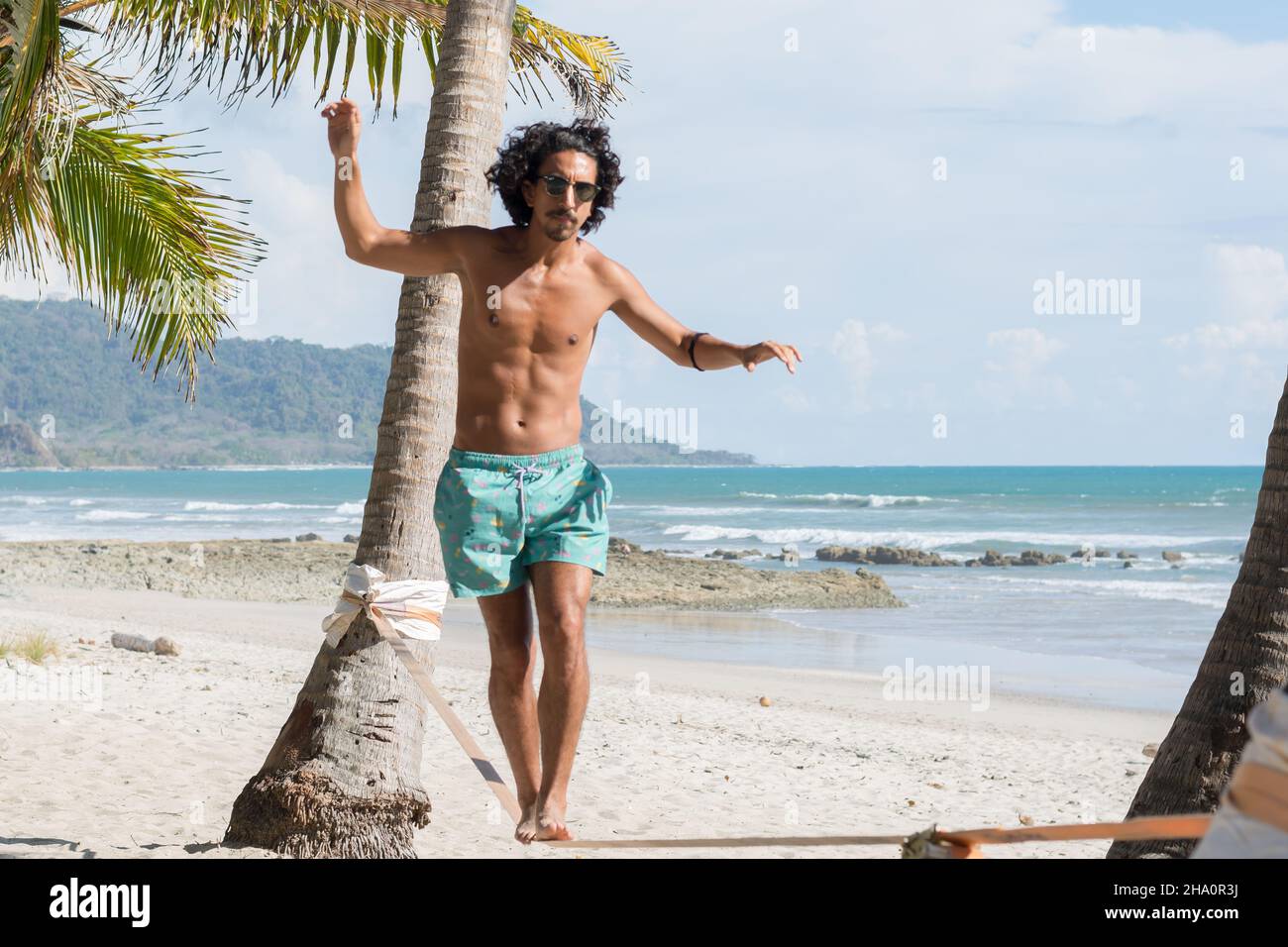 Man doing slackline on the beach Stock Photo - Alamy