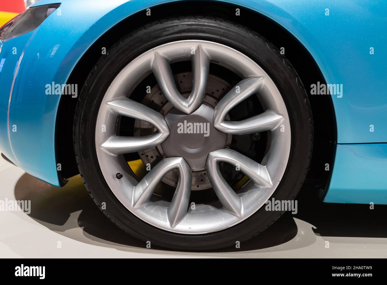 Wheel on light alloy rim of a conceptual blue sports car, close up ...