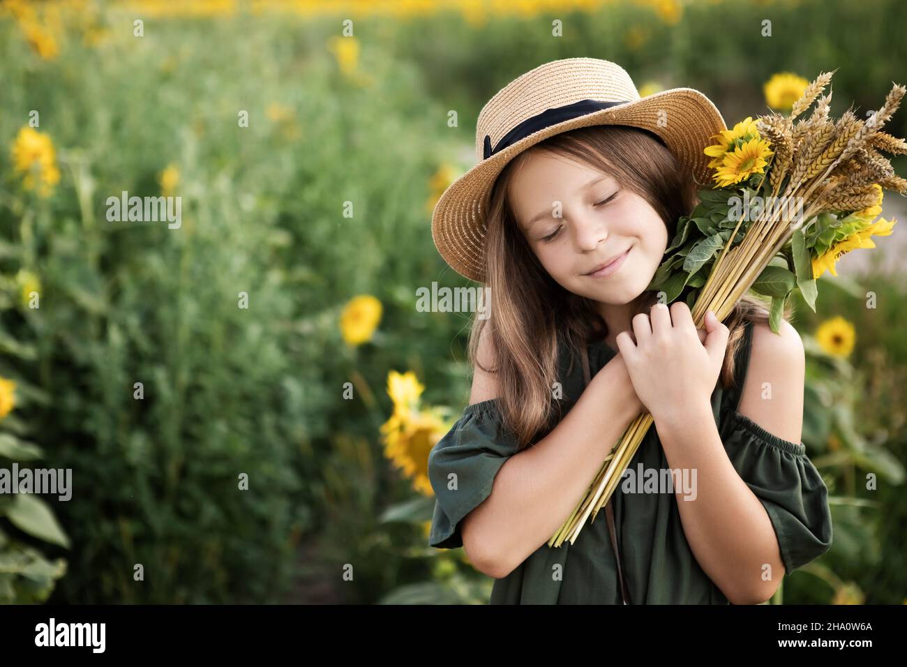 Little girl blogger in the sunflowers. In a hat and a beautiful dress ...