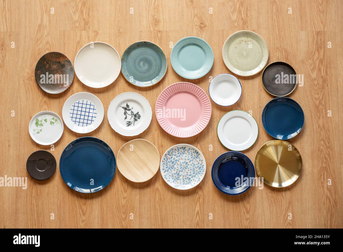 Set of plates of different materials, styles and colors on oak wood ...