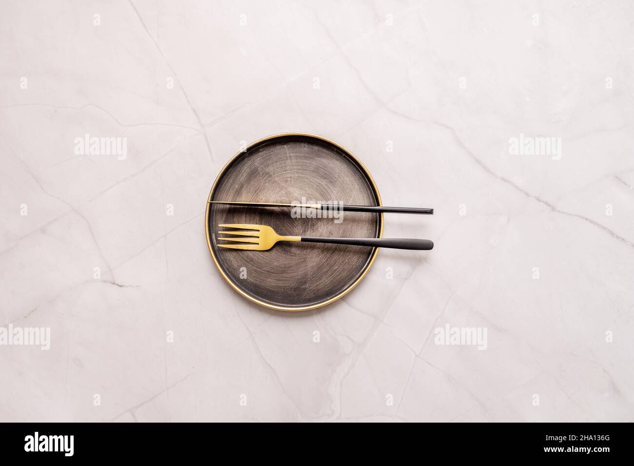 Top view image of vintage metal plate with golden cutlery with black ...