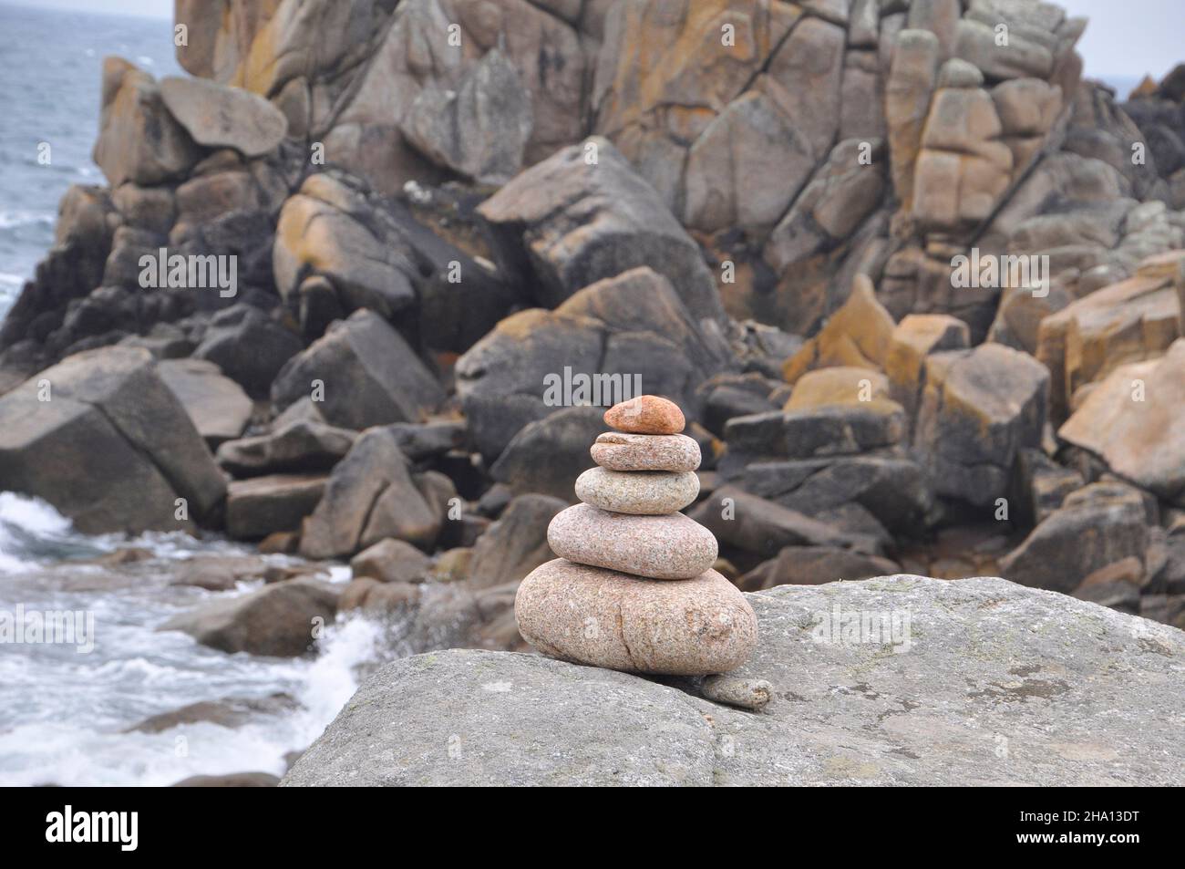 Pebble pillar close to the sea on a rock on St Agnes, an island in the ...