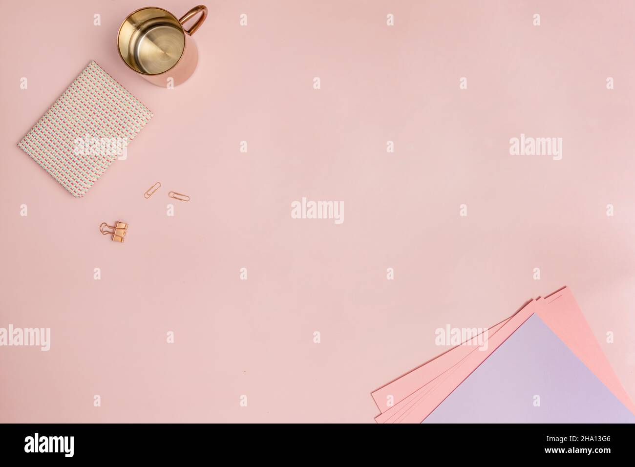 Still life top view of writer in pastel pink tones with copper jug ...