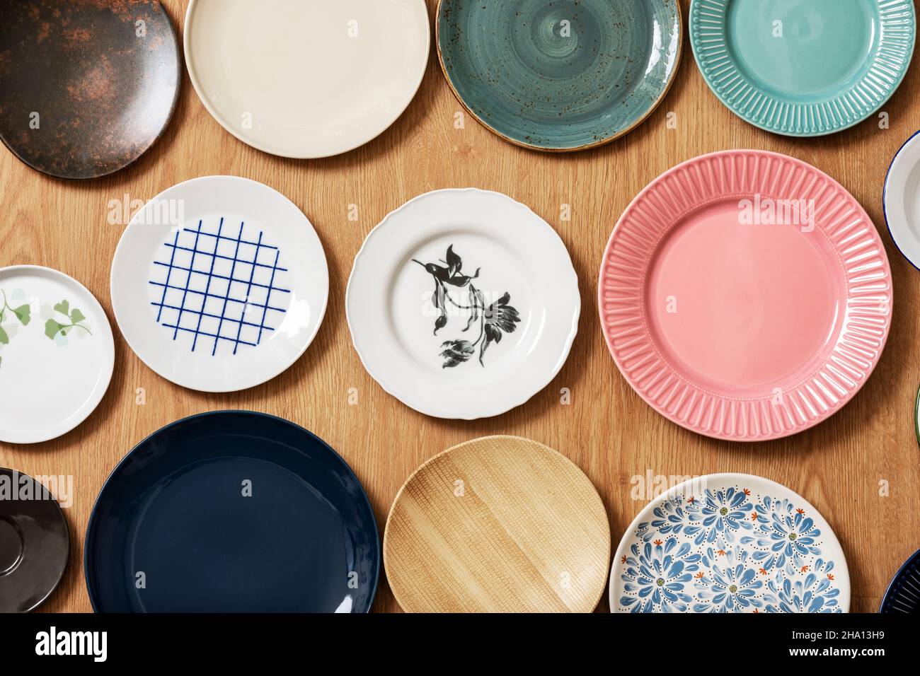Set of plates of different materials, styles and colors on oak wood ...