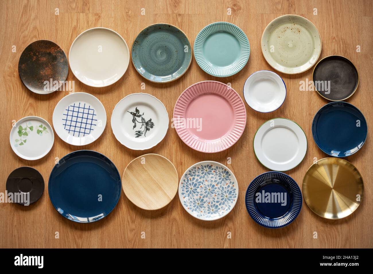 Set of plates of different materials, styles and colors on oak wood ...