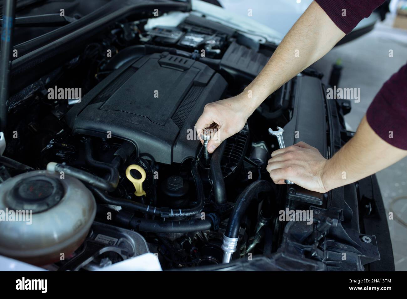 A male automech is inspecting the car's engine. Car service and car ...