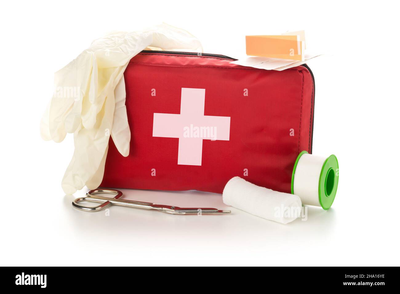 Red first aid medical kit bag with scissors, tape and gloves standing ...