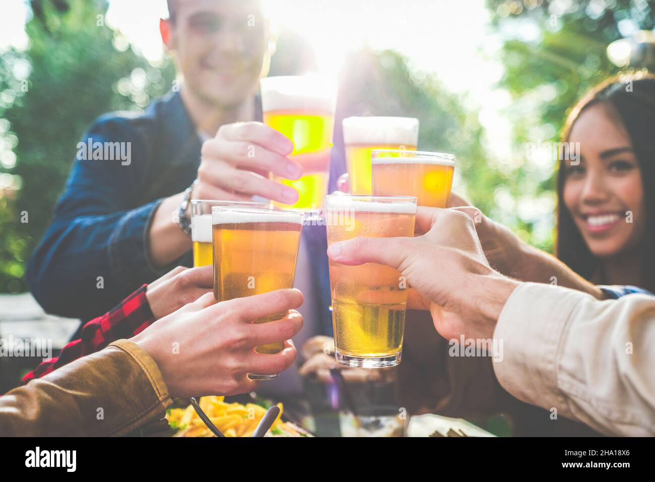 Group of multiethnic friends drinking beer at outdoor pub restaurant ...