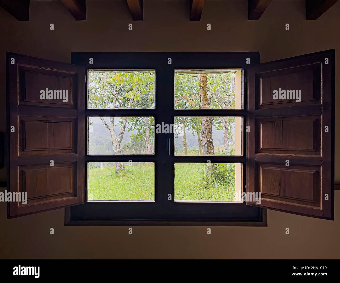 window of a rural house with the shutters open, with a view of a forest ...