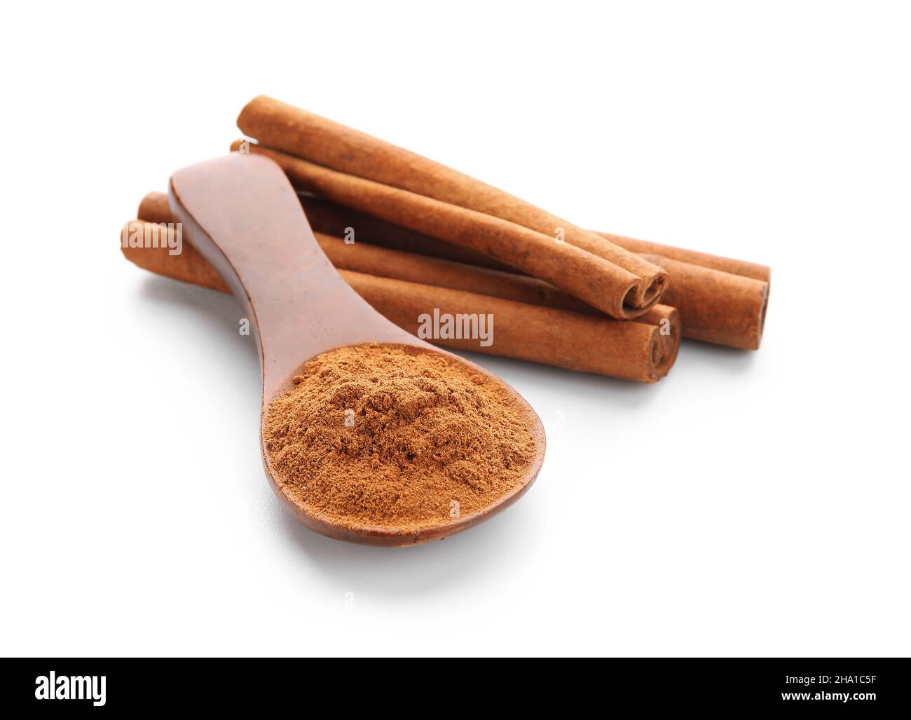 Spoon with natural cinnamon powder and sticks on white background Stock ...