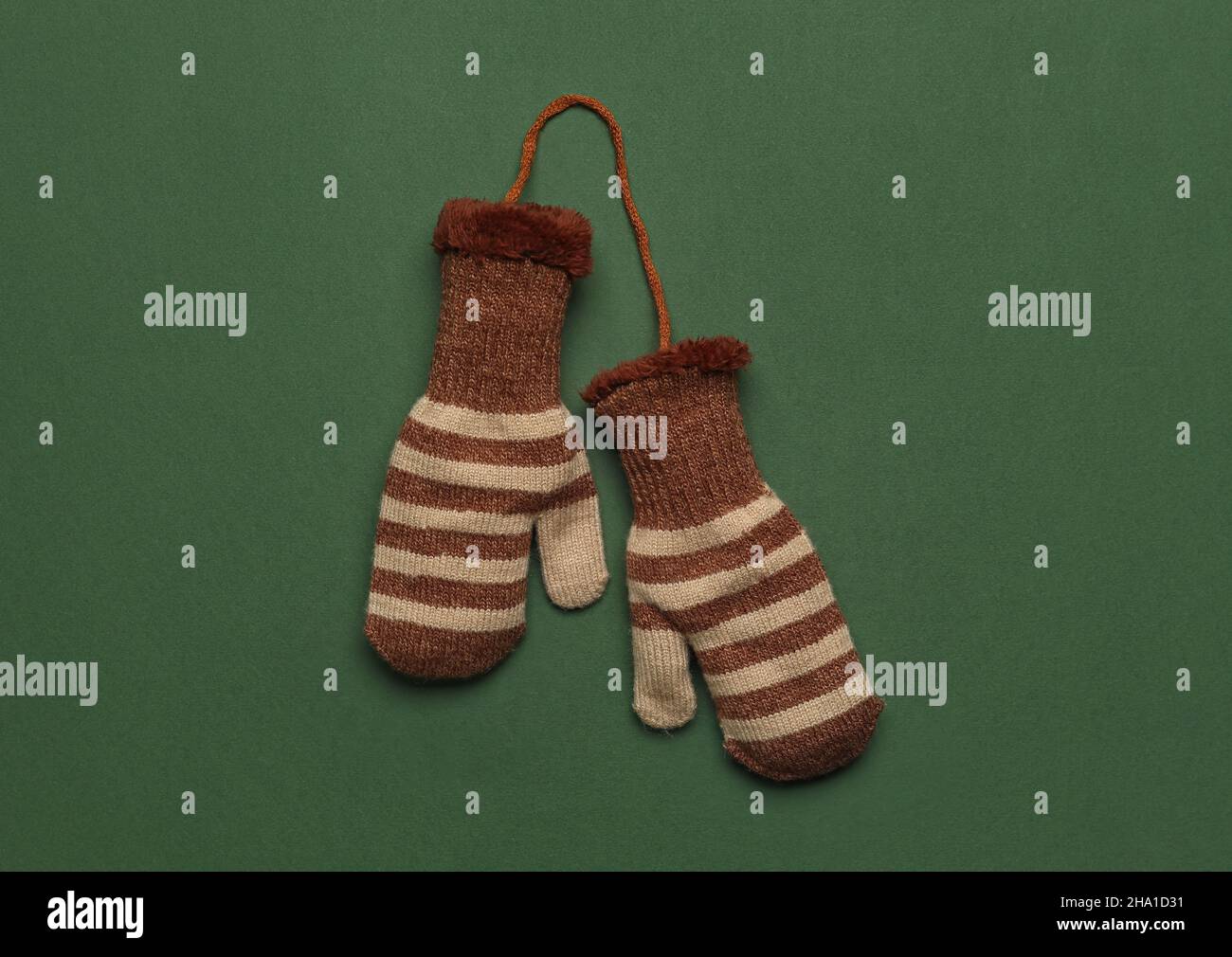 Pair of warm mittens on green background Stock Photo - Alamy