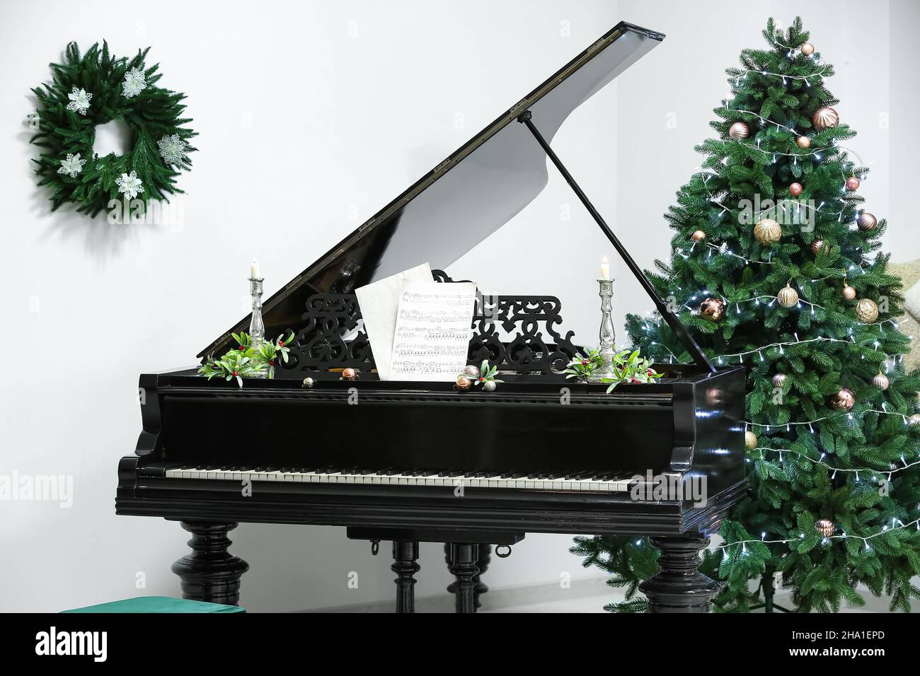 Beautiful grand piano with note sheets in room decorated for Christmas ...