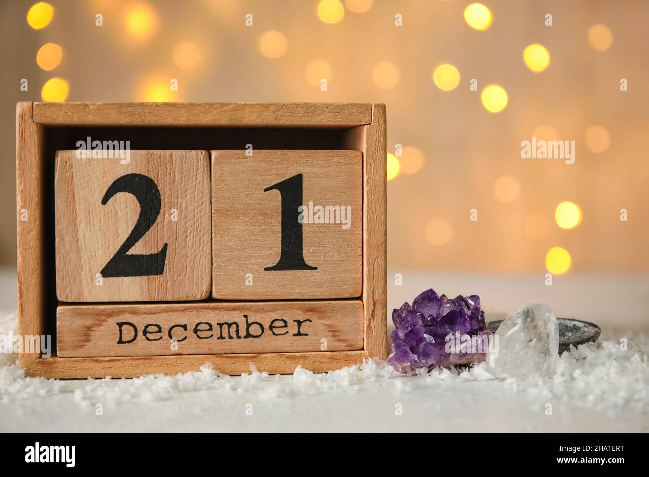 Calendar with date DECEMBER, 21 and gemstones on snow against blurred ...