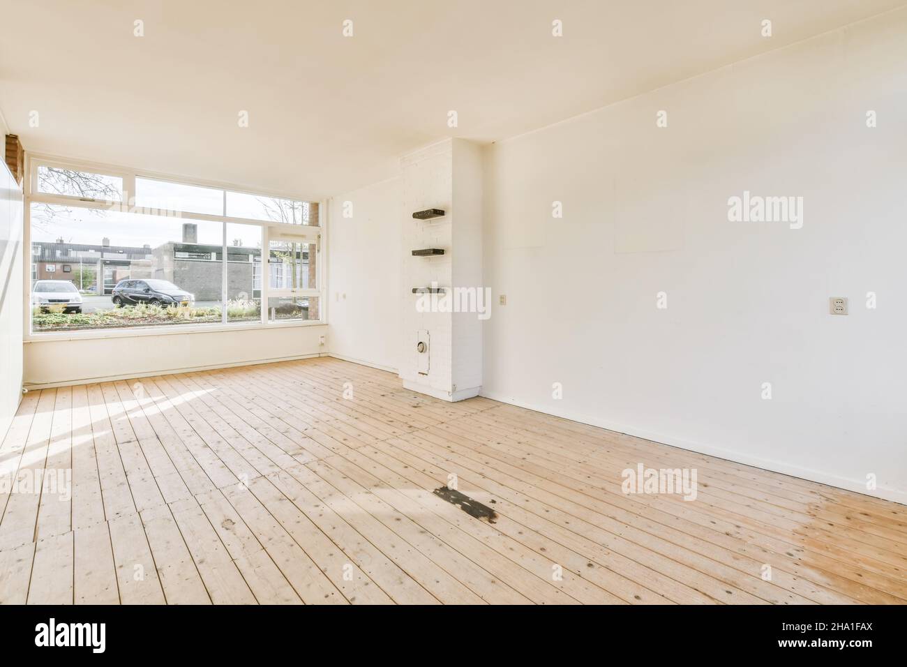 Large cozy empty room with window and wooden floor Stock Photo - Alamy