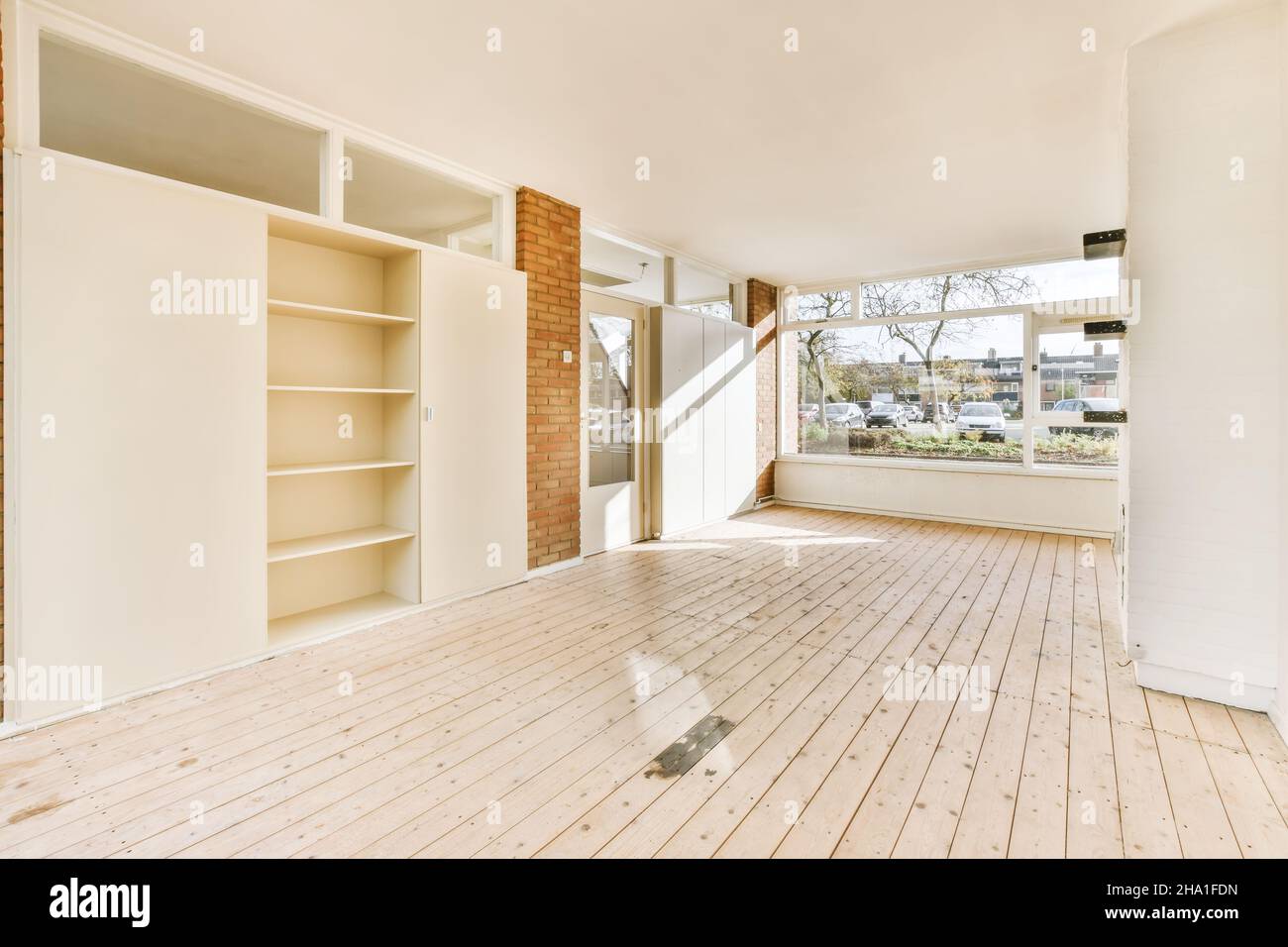 Large cozy empty room with window and wooden floor Stock Photo - Alamy