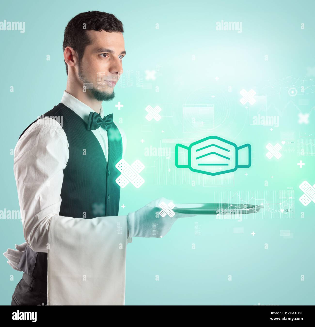 Handsome young waiter in tuxedo holding healthcare icons on tray Stock ...