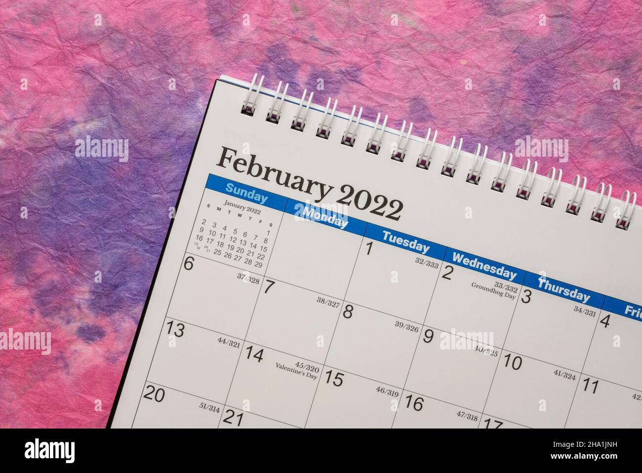 February 2022 - spiral desktop calendar against colorful marbled paper ...