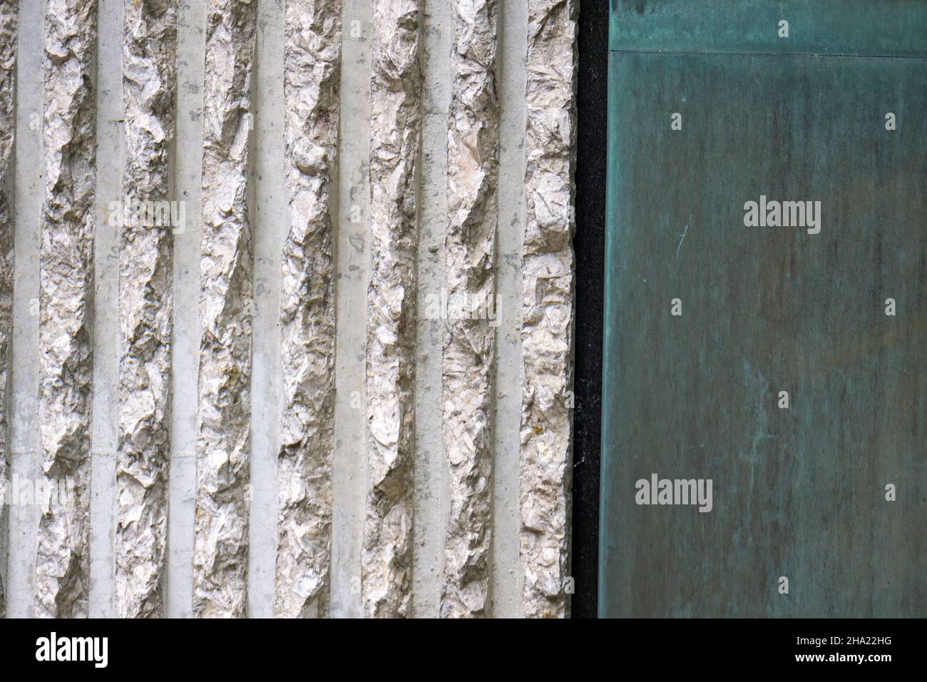 Rough aged wall with jagged rocky bumps running vertically beside a ...