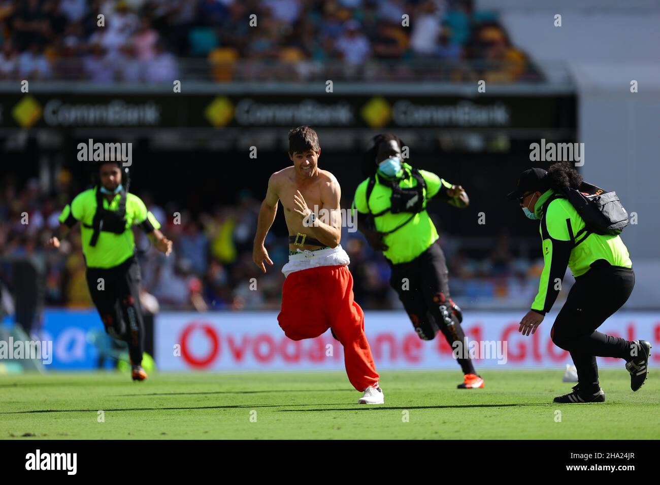 A pitch invader enters the field of play at The Gabba, and is chased by ...