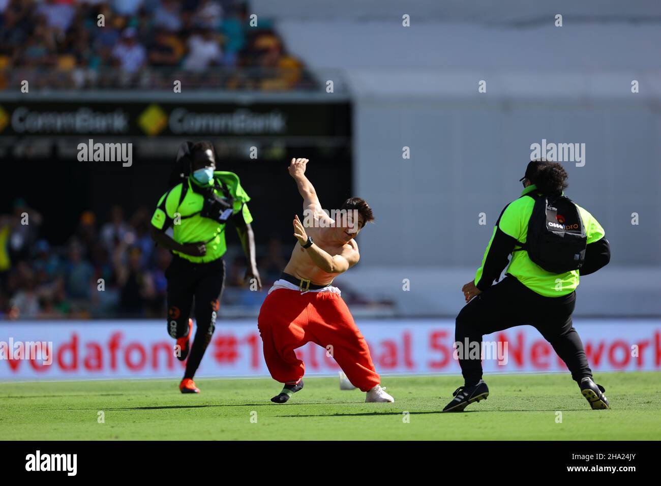 A pitch invader enters the field of play at The Gabba, and is chased by ...