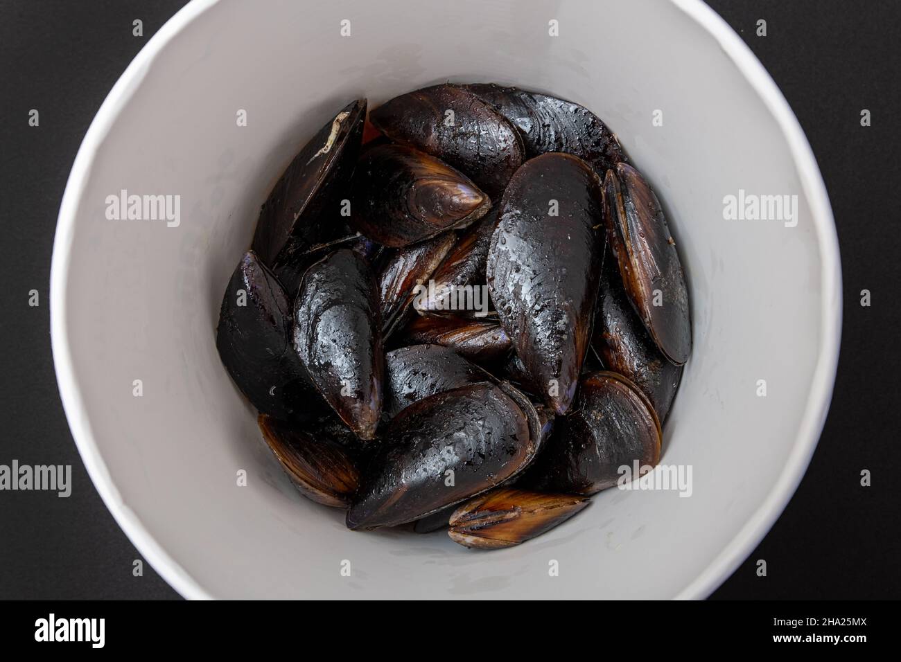 Fresh stuffed mussels in bucket on dark stone background Stock Photo ...