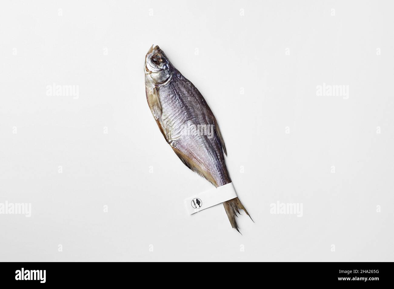 Dried salted roach fish with label on tail isolated on white background ...