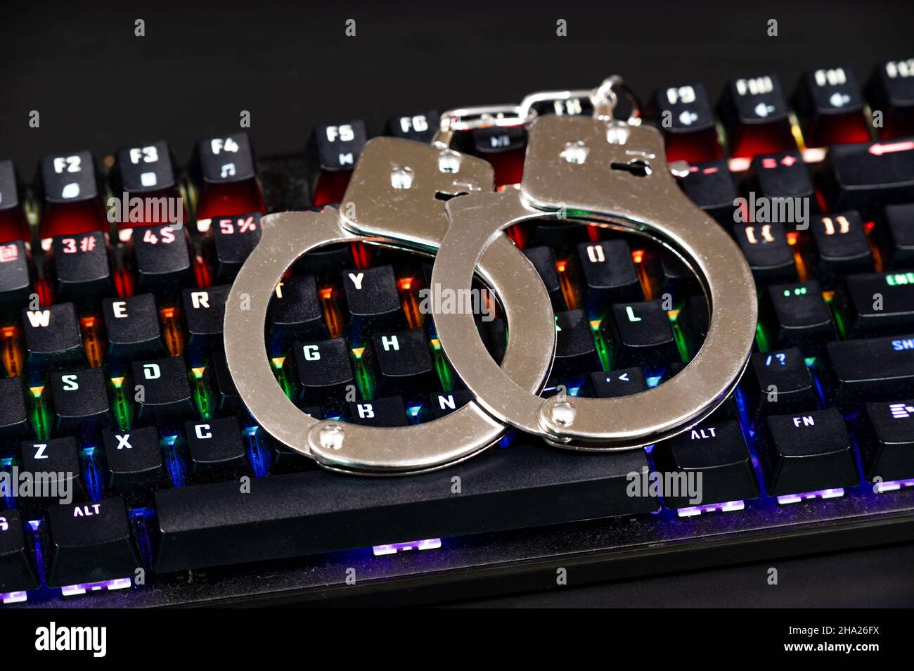 Keyboard and handcuffs with LED lights on. Cybercrime concept Stock ...