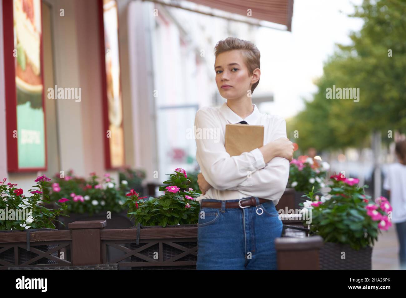 student with a book in his hands outdoors in a summer cafe rest ...