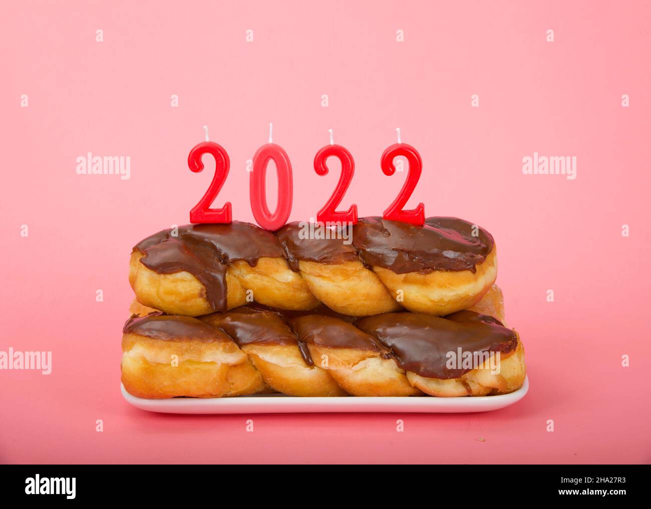 Chocolate frosted glazed twist donuts stacked on a rectangular plate ...