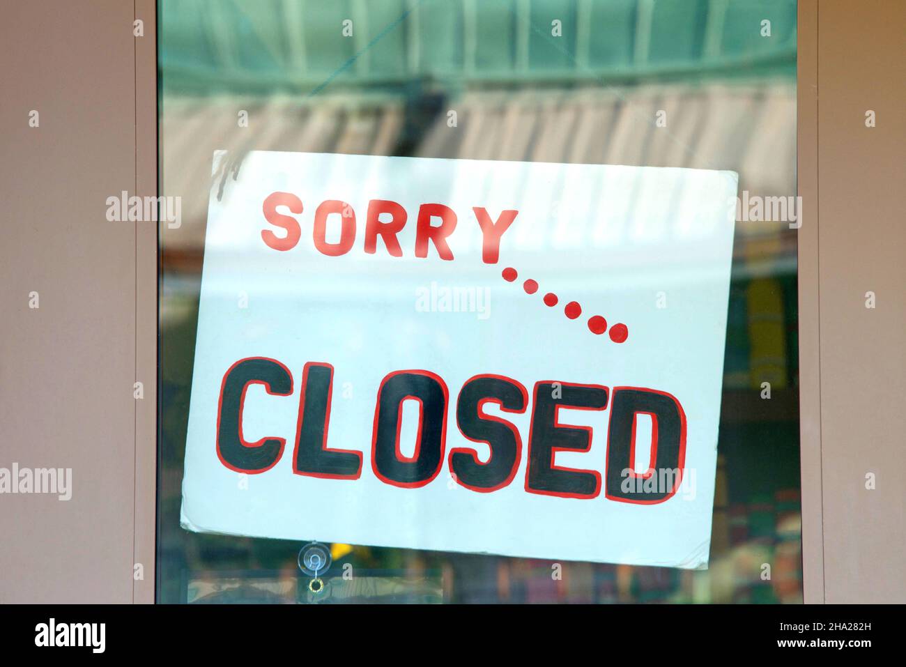 Close up on Sorry... Closed sign in glass window on brown wood door ...