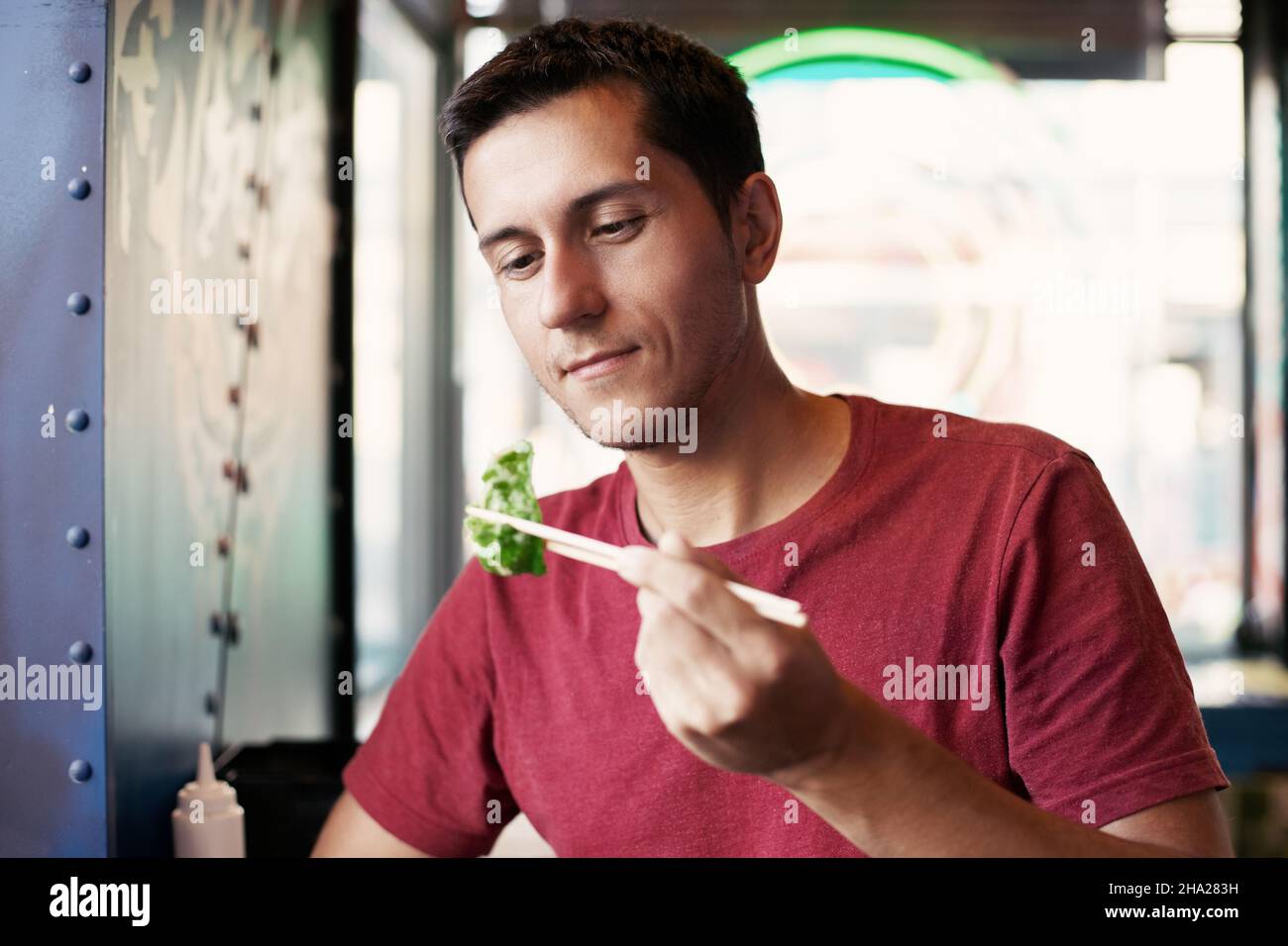 Happy man eating asian japanese dumplings Jiaozi in fastfood restaurant ...
