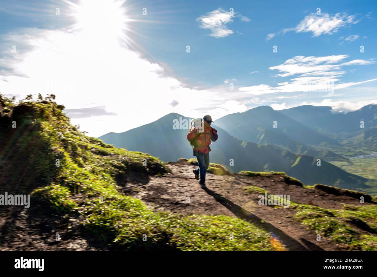 Man running on ridge of the mountain Stock Photo - Alamy