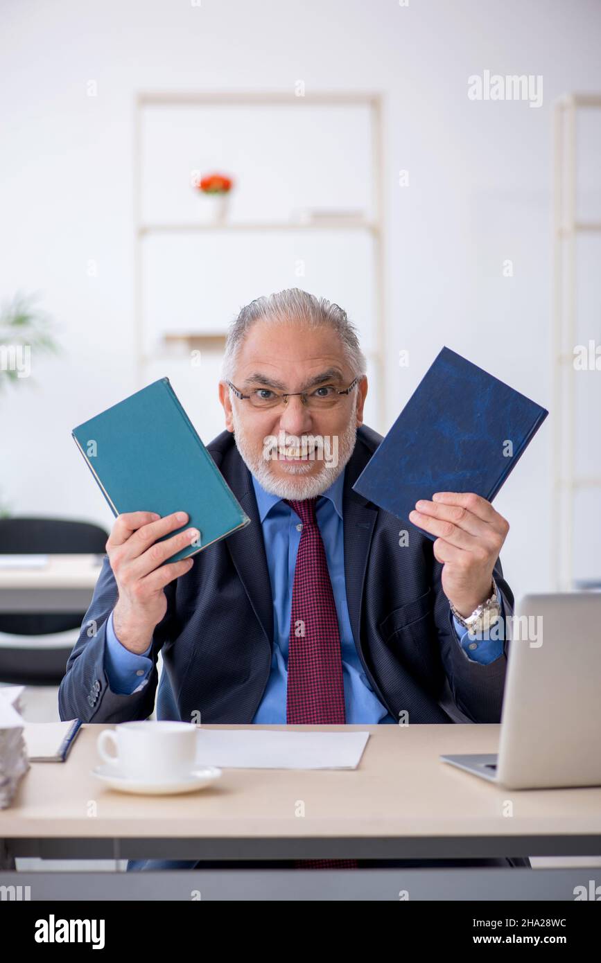 Old businessman employee reading book at workplace Stock Photo - Alamy