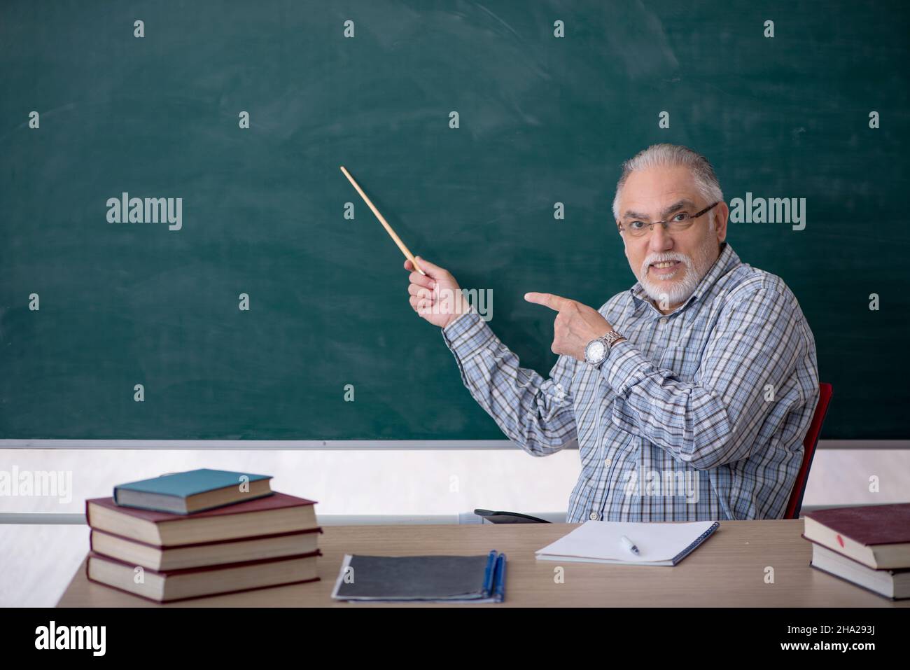 Aged male teacher in the classroom Stock Photo - Alamy