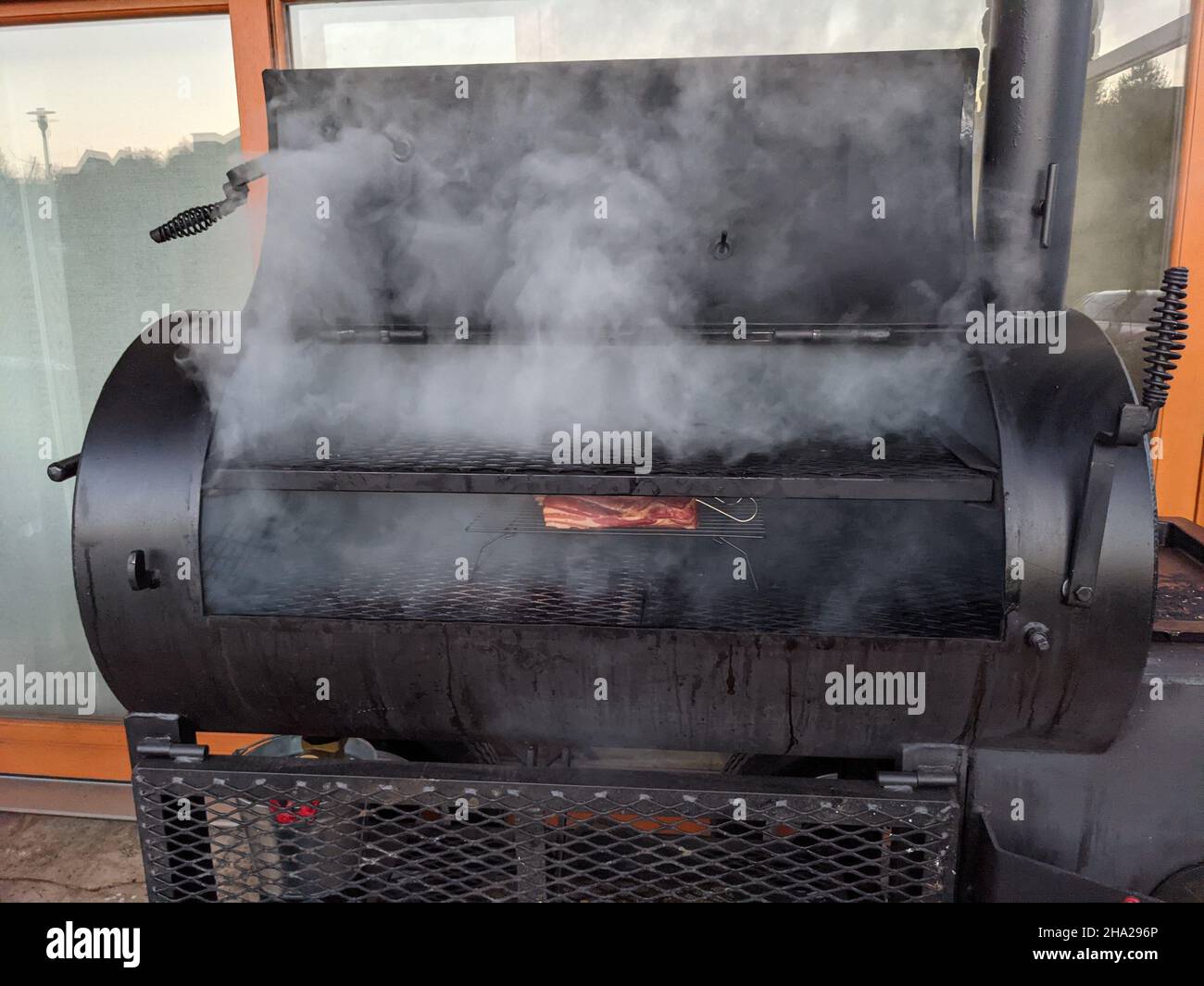 Slice of meat being cooked in a charcoal smoker Stock Photo - Alamy